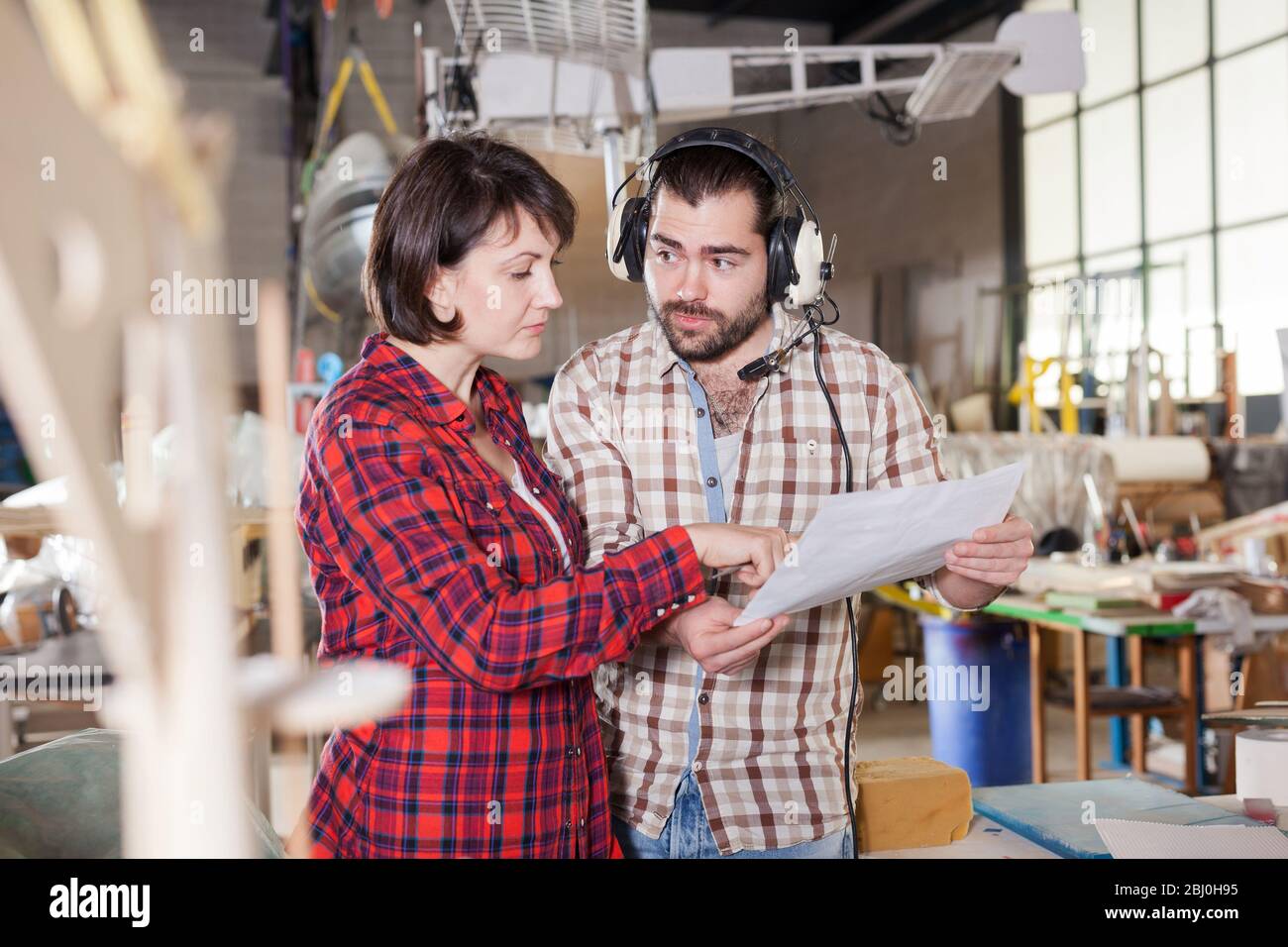 Team of aircraft enthusiasts working in workshop on creating of ...