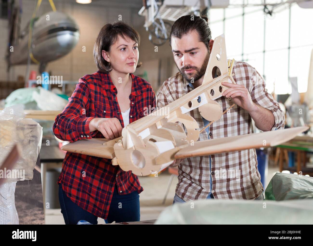 Team of aircraft enthusiasts working in workshop on creating of ...