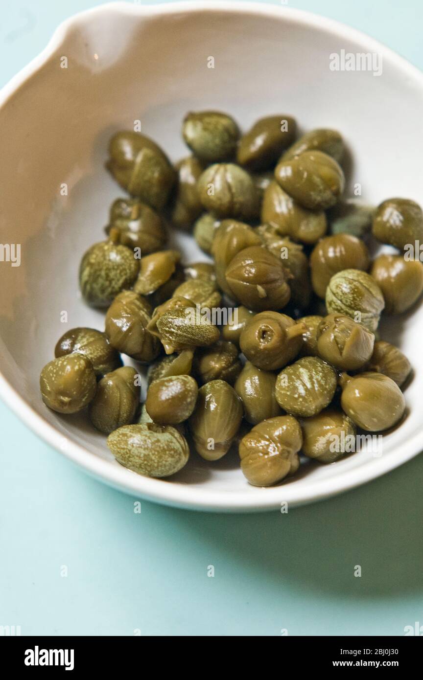 Small white bowl of Italian capers Stock Photo - Alamy