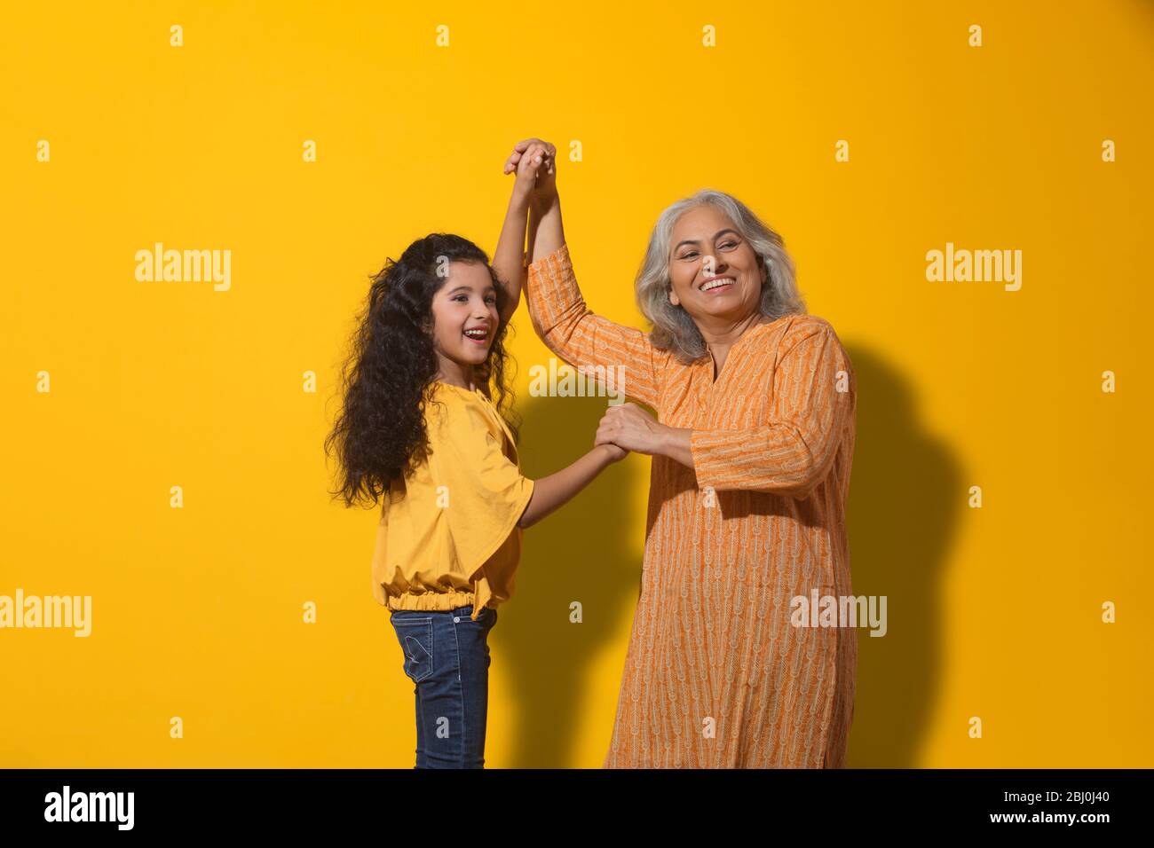 Portrait of a happy grandmother dancing with her grand-daughter Stock ...