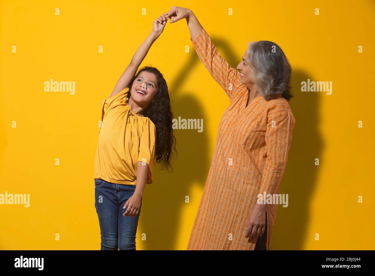 Portrait of a happy grandmother dancing with her grand-daughter Stock ...