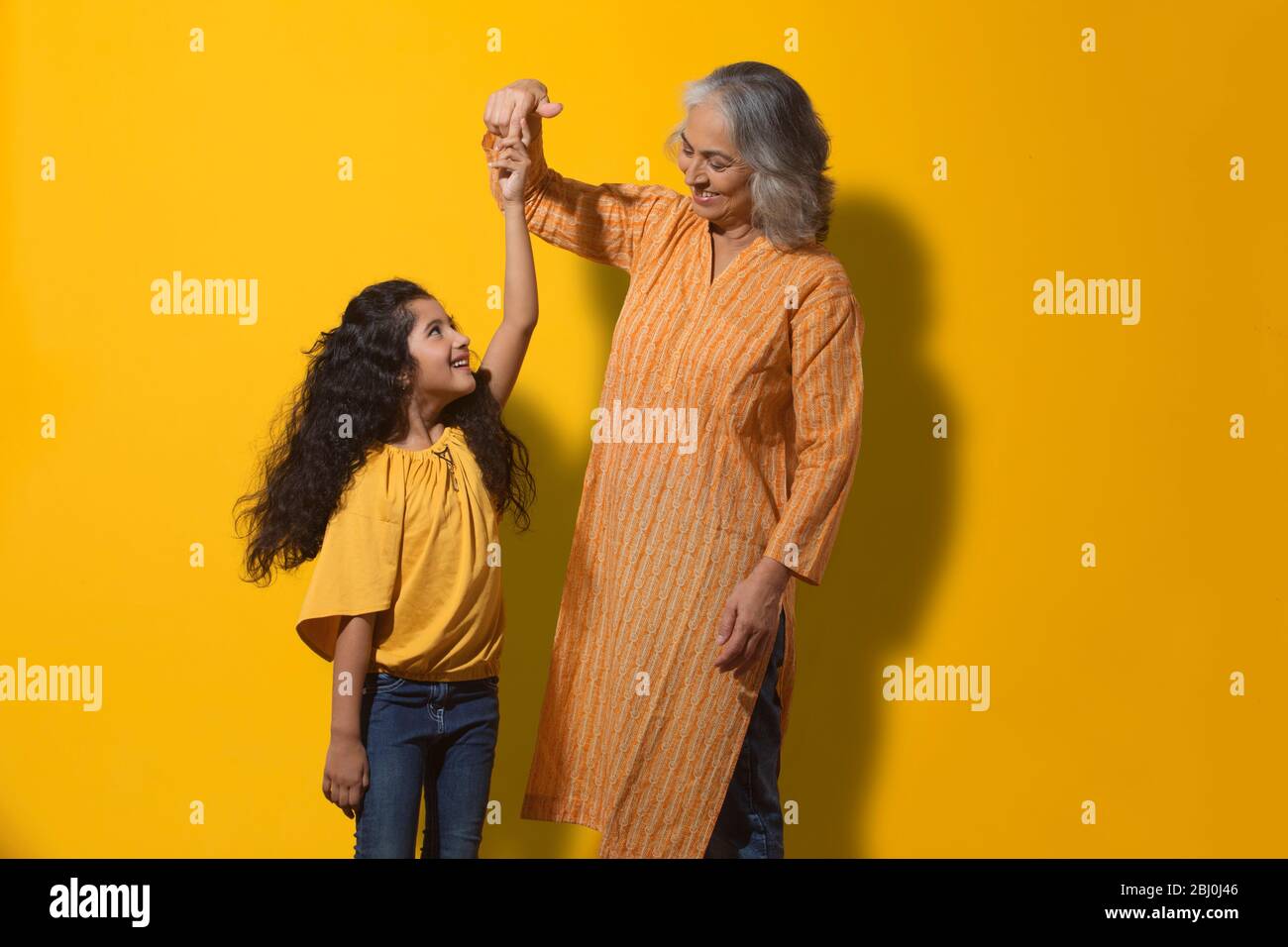 Portrait of a happy grandmother dancing with her grand-daughter Stock ...