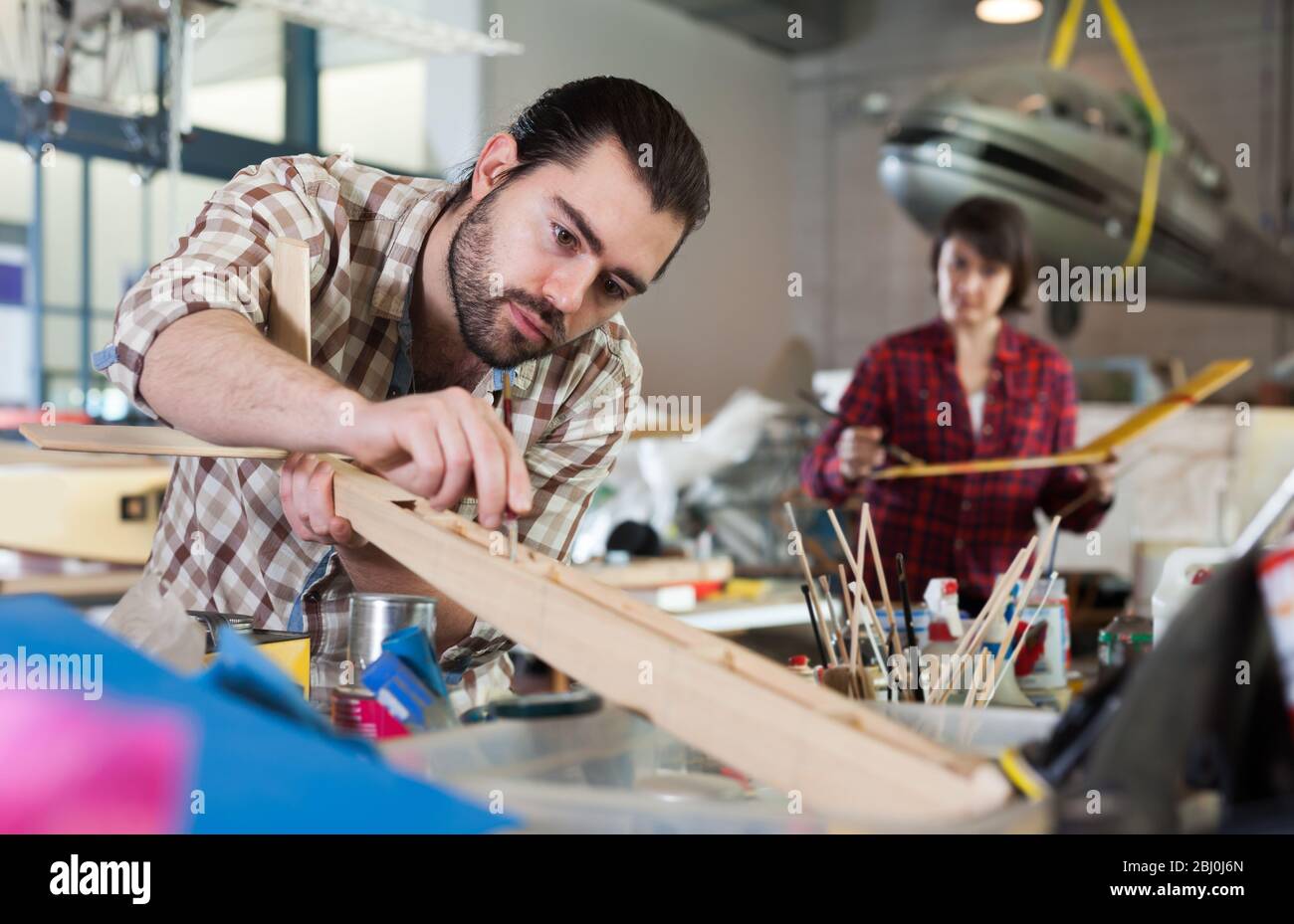 Nice male aircraft enthusiast working in workshop on creating of ...