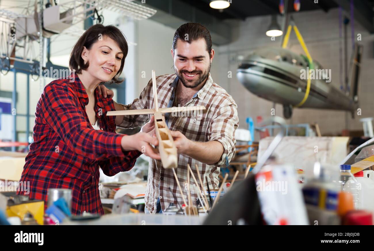 Team of adult aircraft enthusiasts working in workshop on creating of ...