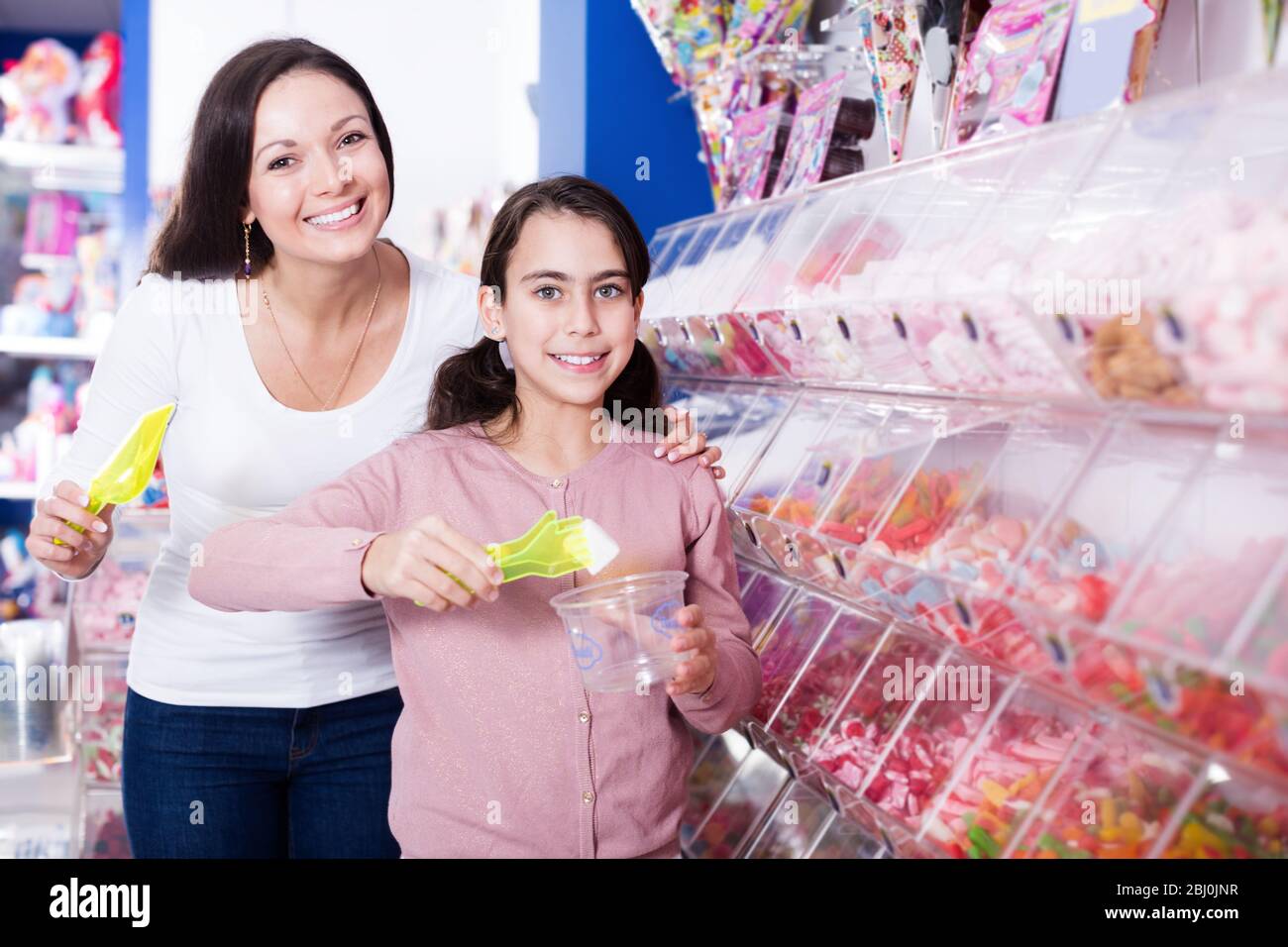 Smiling woman with daughter looking fruit candy in the candy shop Stock ...