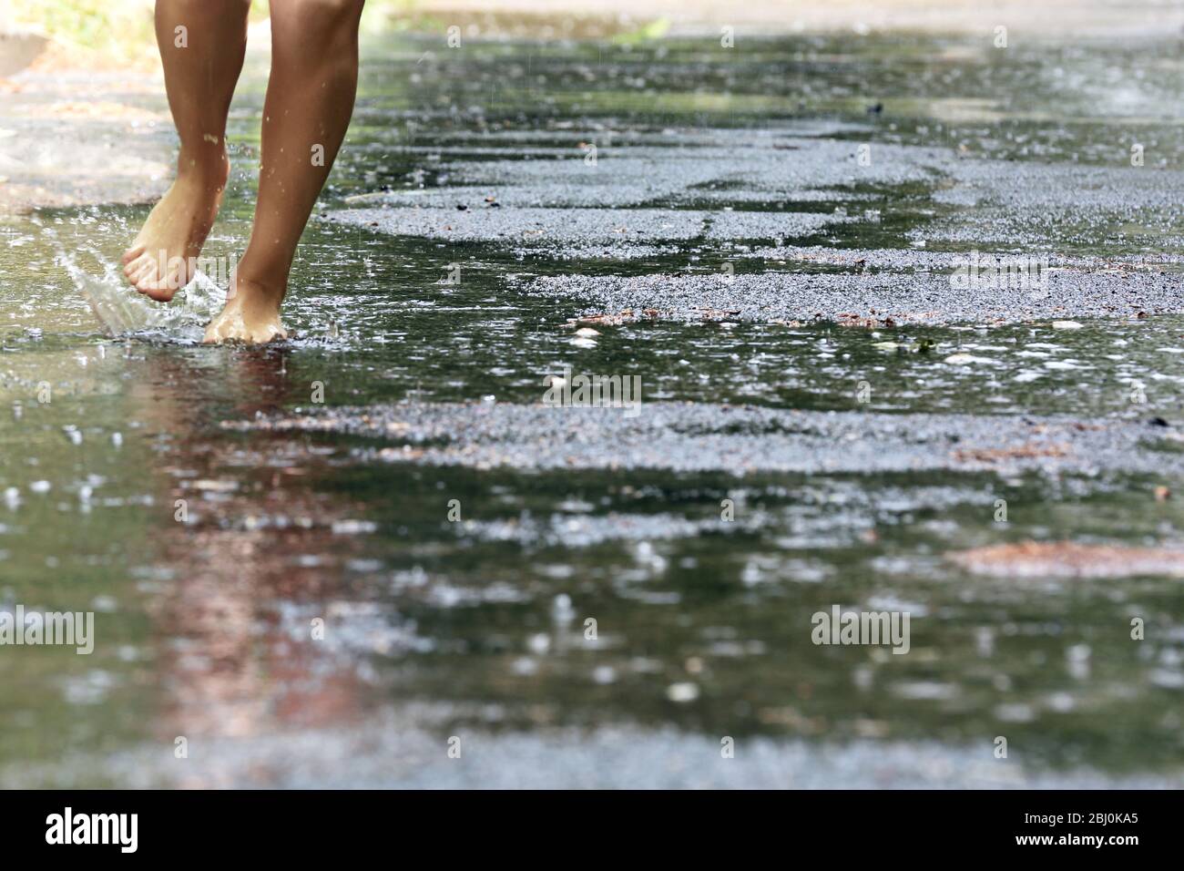 Woman walking barefoot through puddle outdoors Stock Photo - Alamy