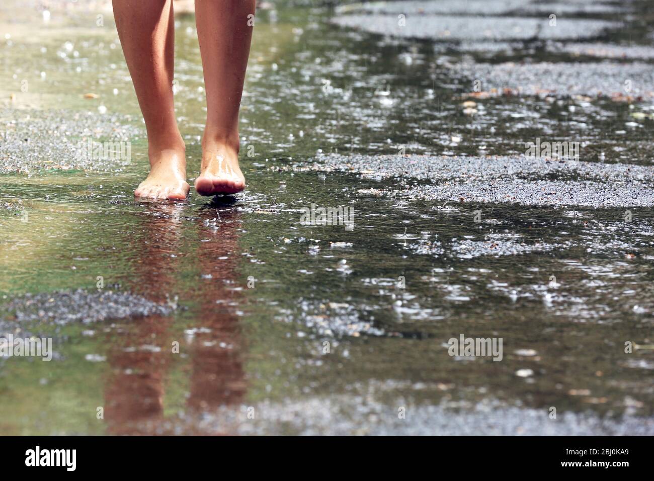 Woman walking barefoot through puddle outdoors Stock Photo - Alamy
