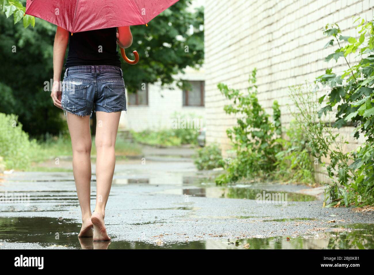 Woman walking barefoot through puddle outdoors Stock Photo - Alamy