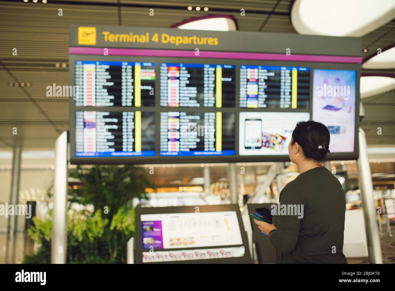 Passenger traveling at the flight information board in airport terminal ...