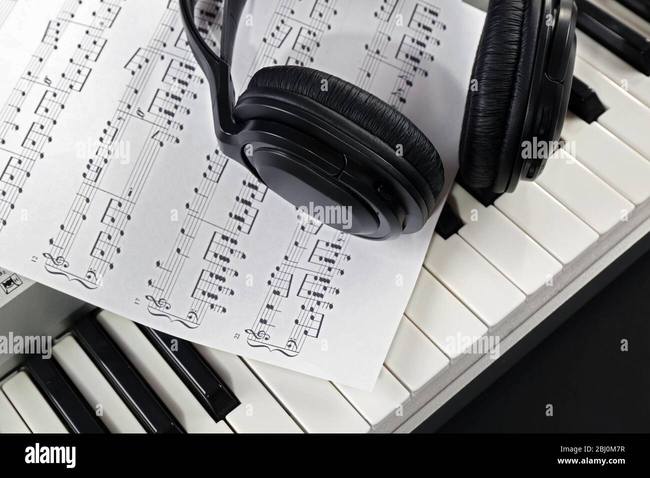 Headphones with music notes on synthesizer close up Stock Photo - Alamy