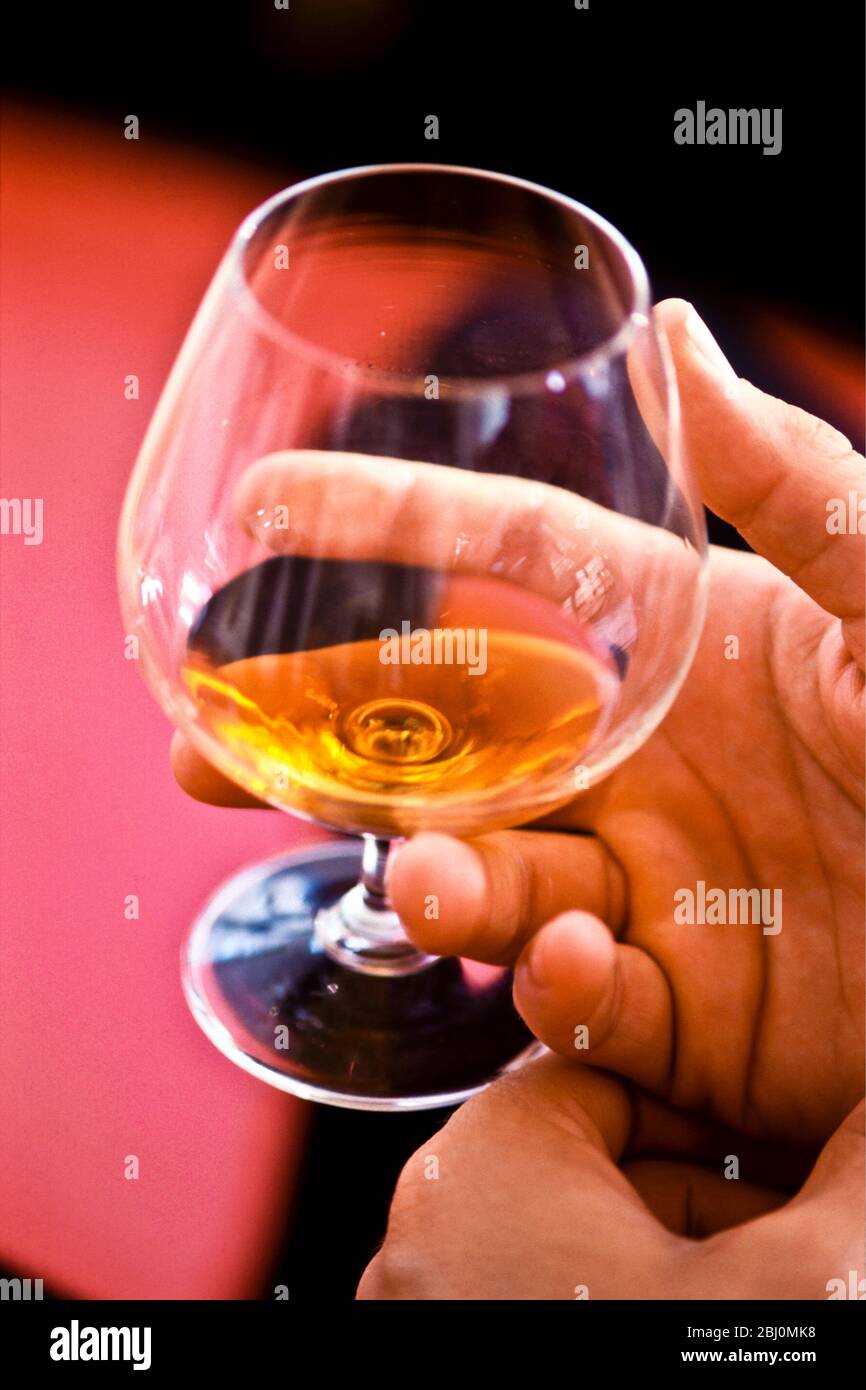 Brandy in brandy goble being warmed in the hand Stock Photo - Alamy