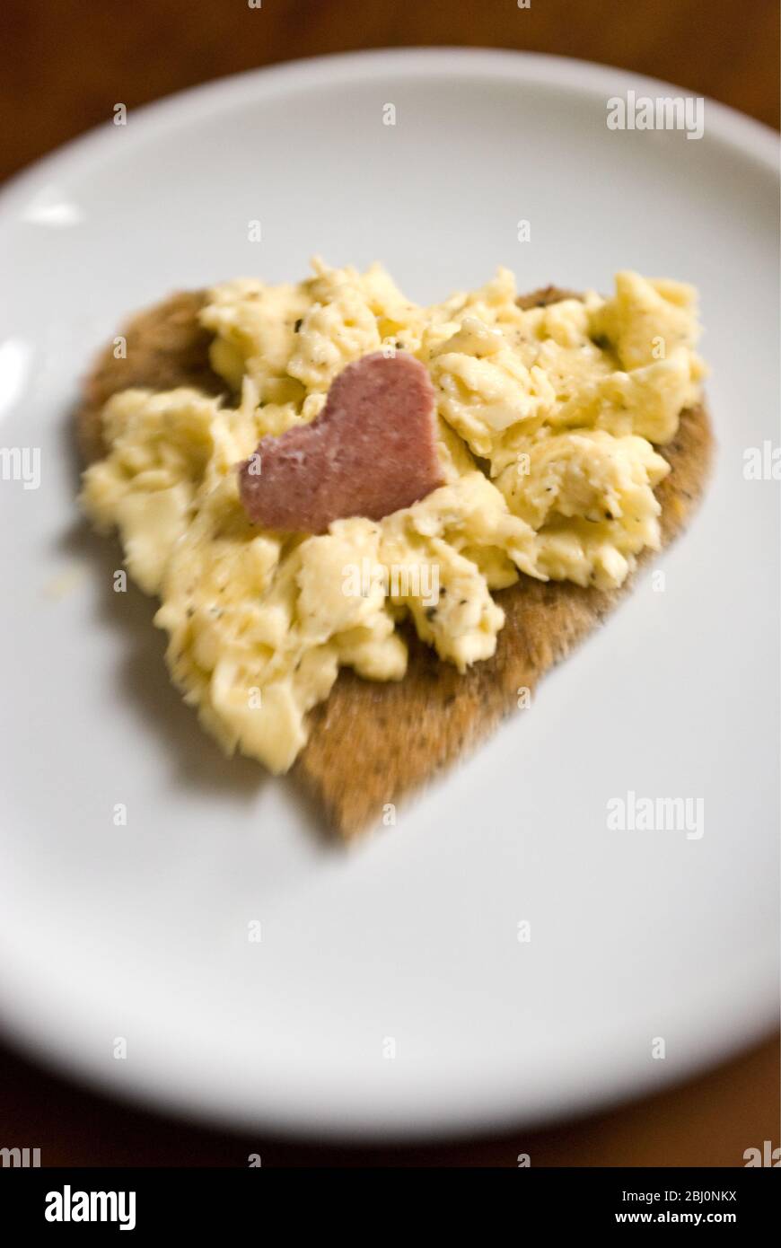 Valentine's day breakfast of scrambled eggs on heart shaped toast with ...