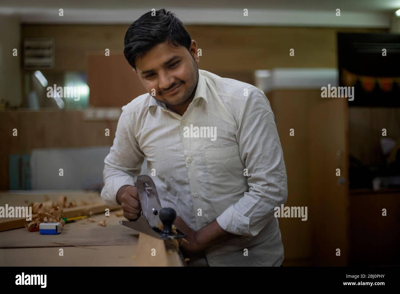 Carpenter shaping the edges of a wooden plank. (Common man Stock Photo ...