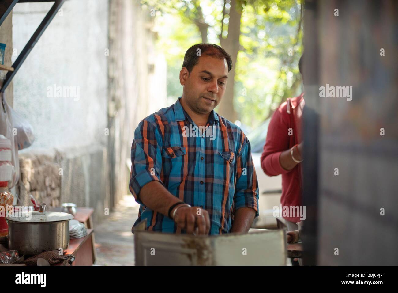 Common man cooking at his roadside stall Stock Photo - Alamy