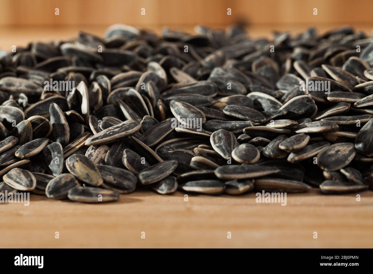 Natural background of sunflower seeds in hulls on wooden surface ...