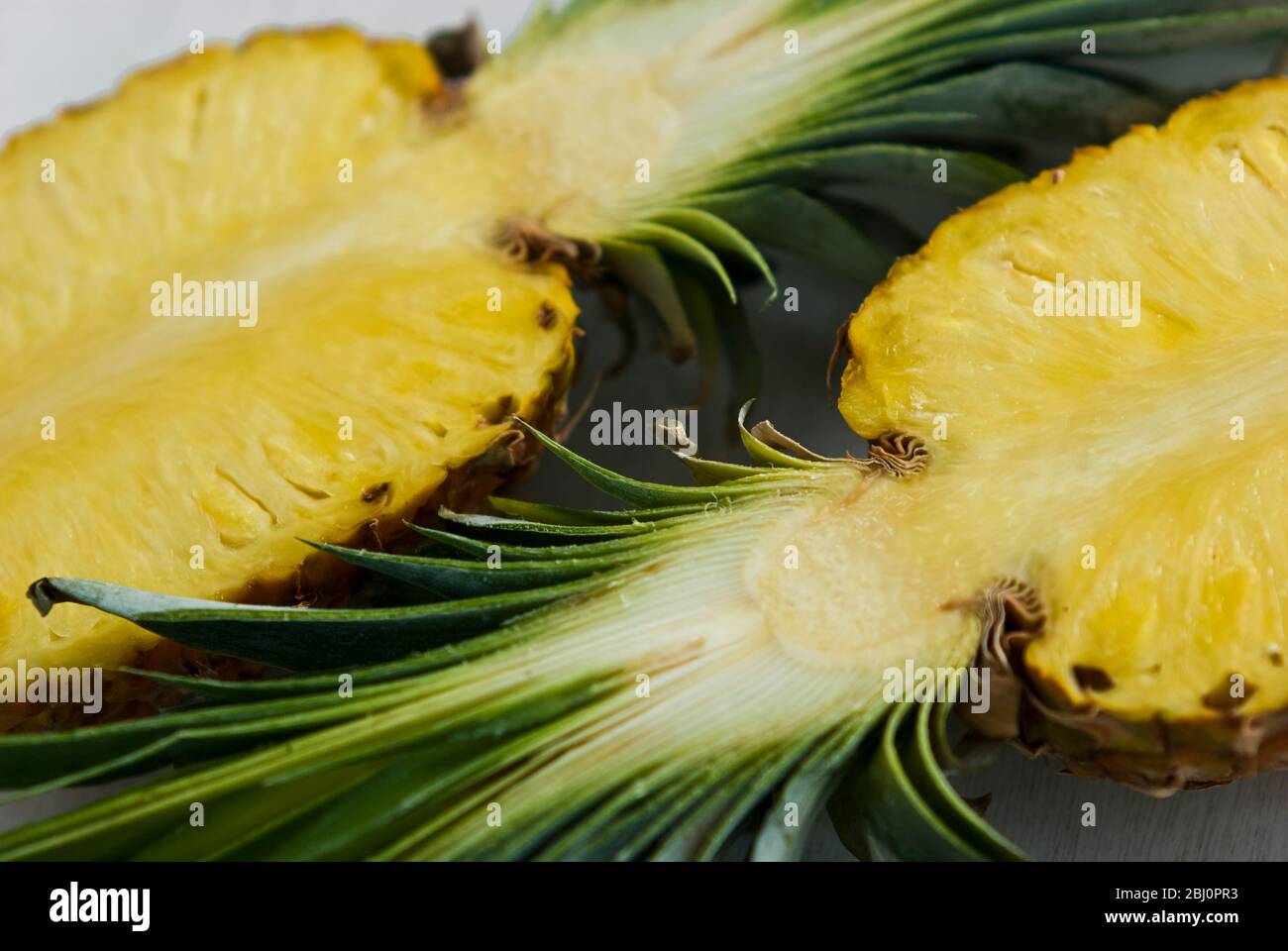 Pineapple cut in half on white background Stock Photo - Alamy