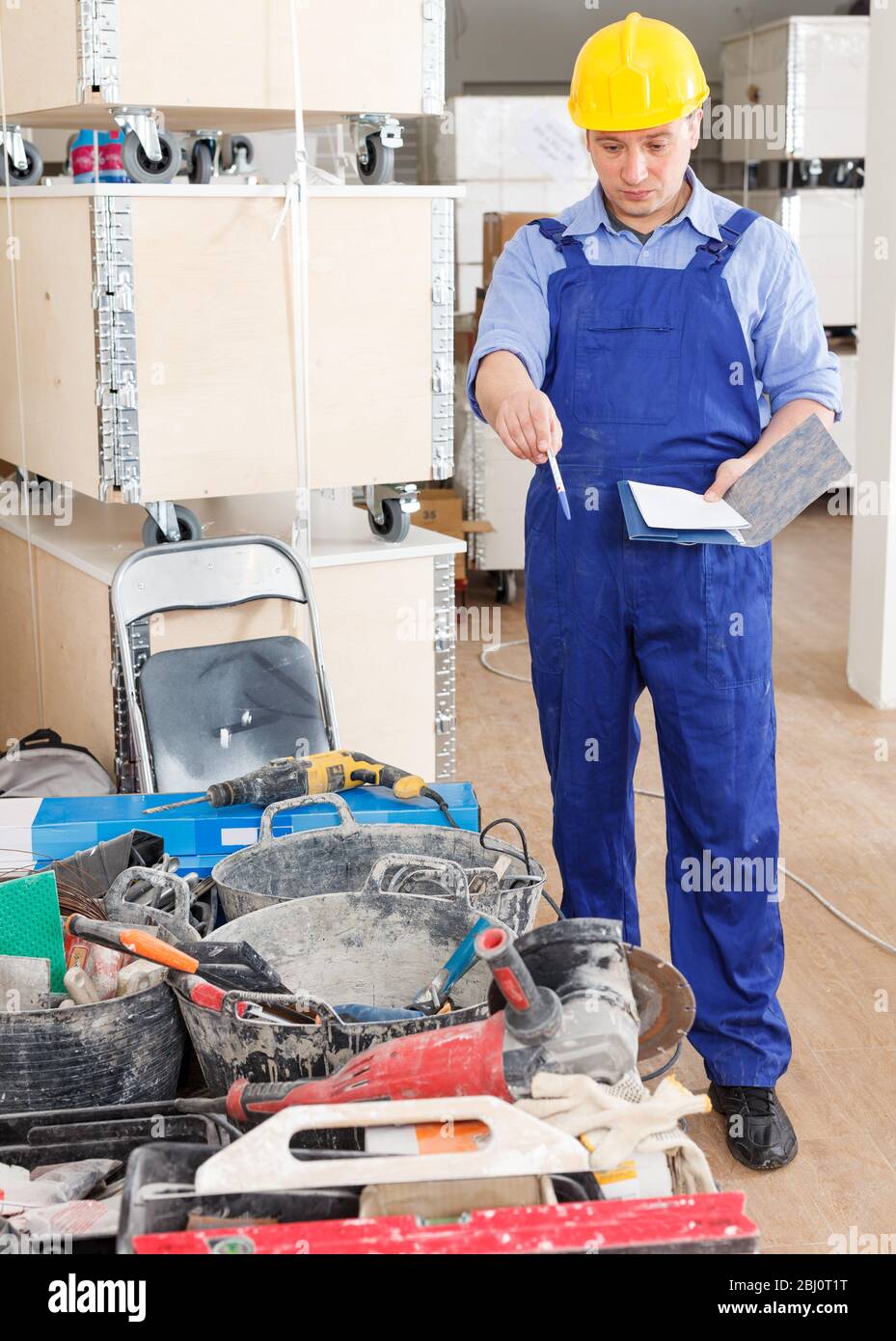 Focused foreman checking materials and tools before construction works ...