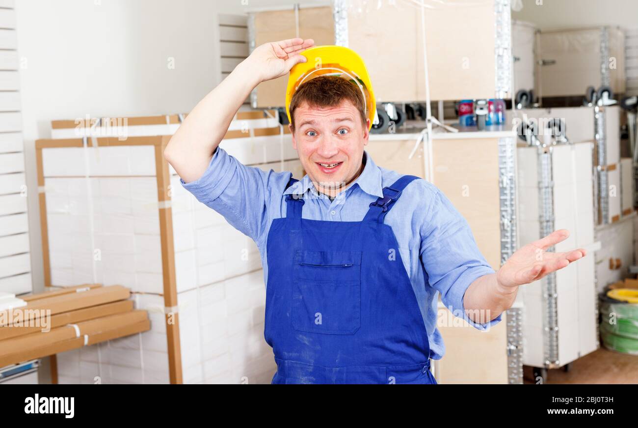 Scared and confused male contractor looking at room and determining ...