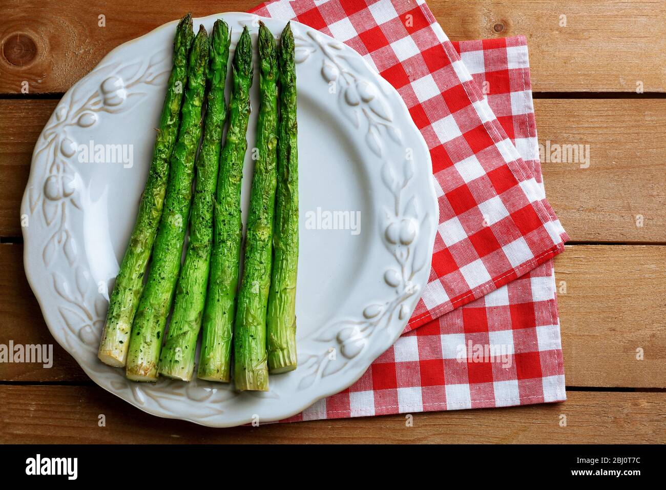 Roasted asparagus on plate on table background Stock Photo - Alamy