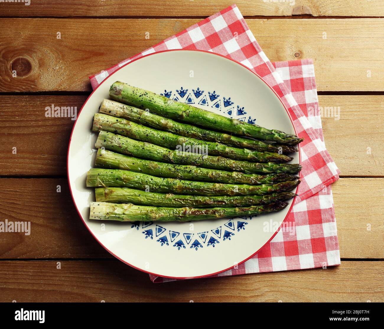 Roasted asparagus on plate on table background Stock Photo - Alamy