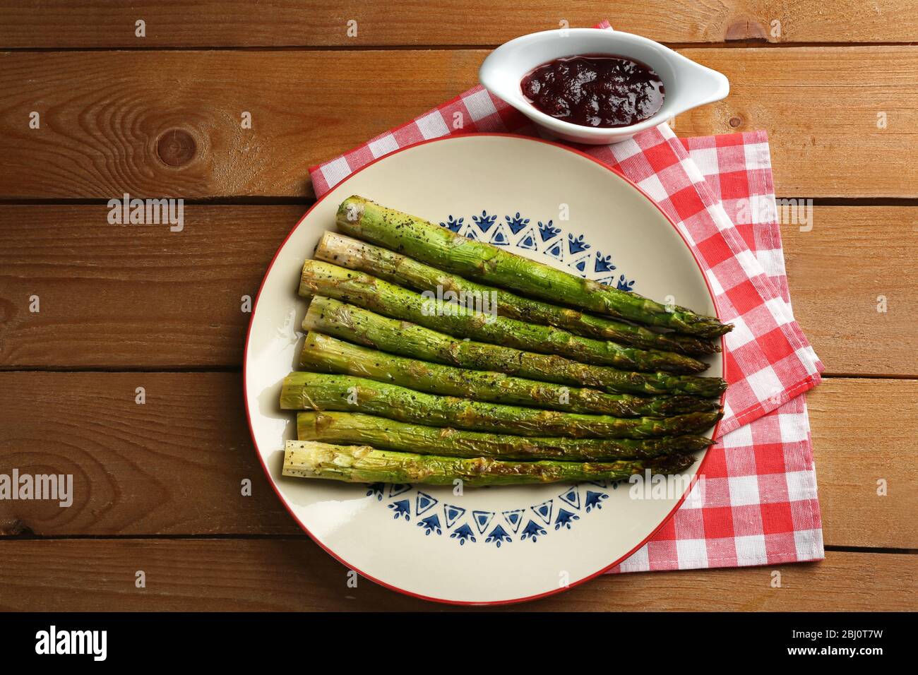 Roasted asparagus on plate on table background Stock Photo - Alamy