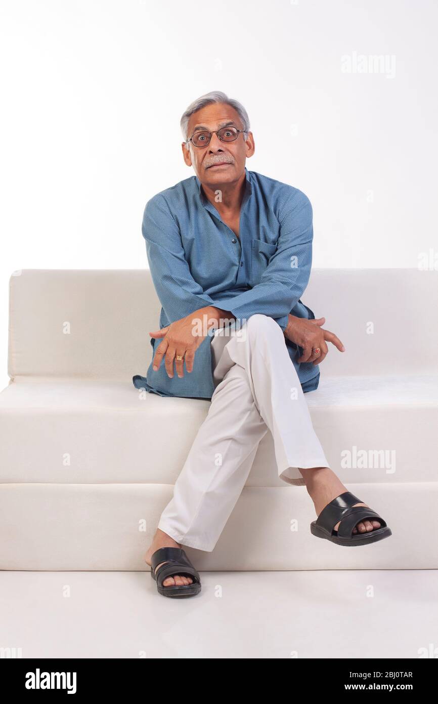 Senior man sitting on the couch Stock Photo - Alamy
