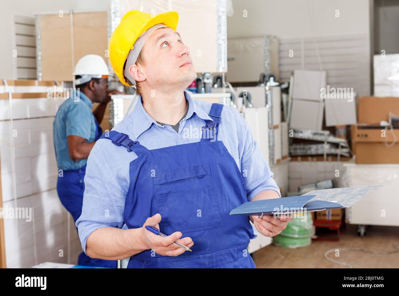 Professional male contractor looking at room and determining scope of ...