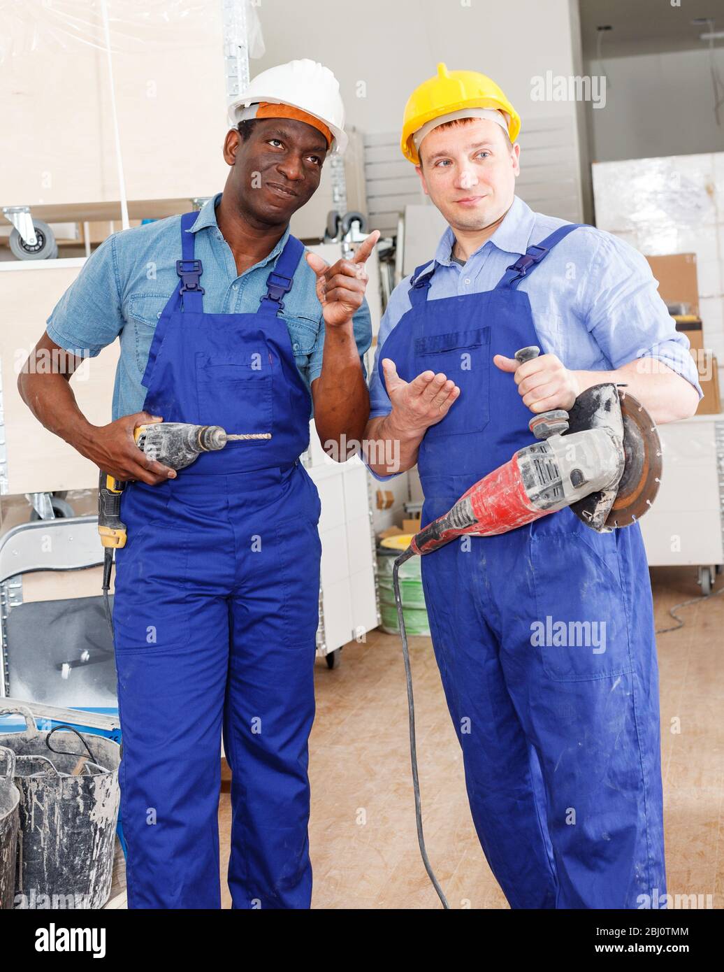 Professional builders using manual power tools during renovation work ...
