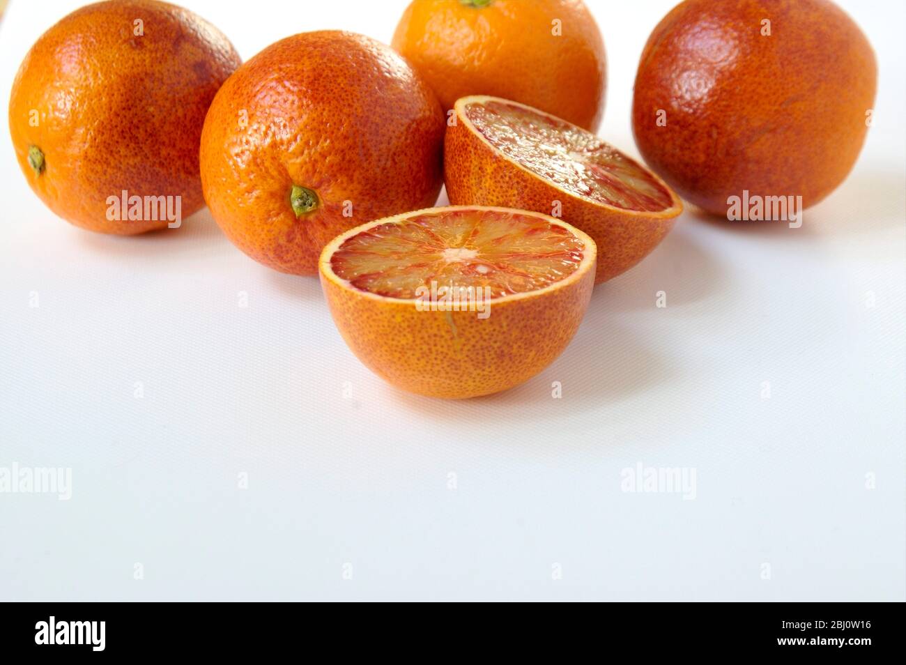 Oranges, cut and whole on white surface Stock Photo - Alamy