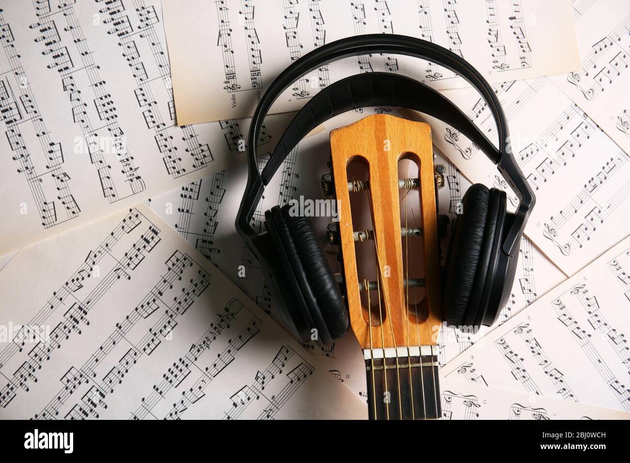 Music recording scene with guitar and headphones on music sheets ...