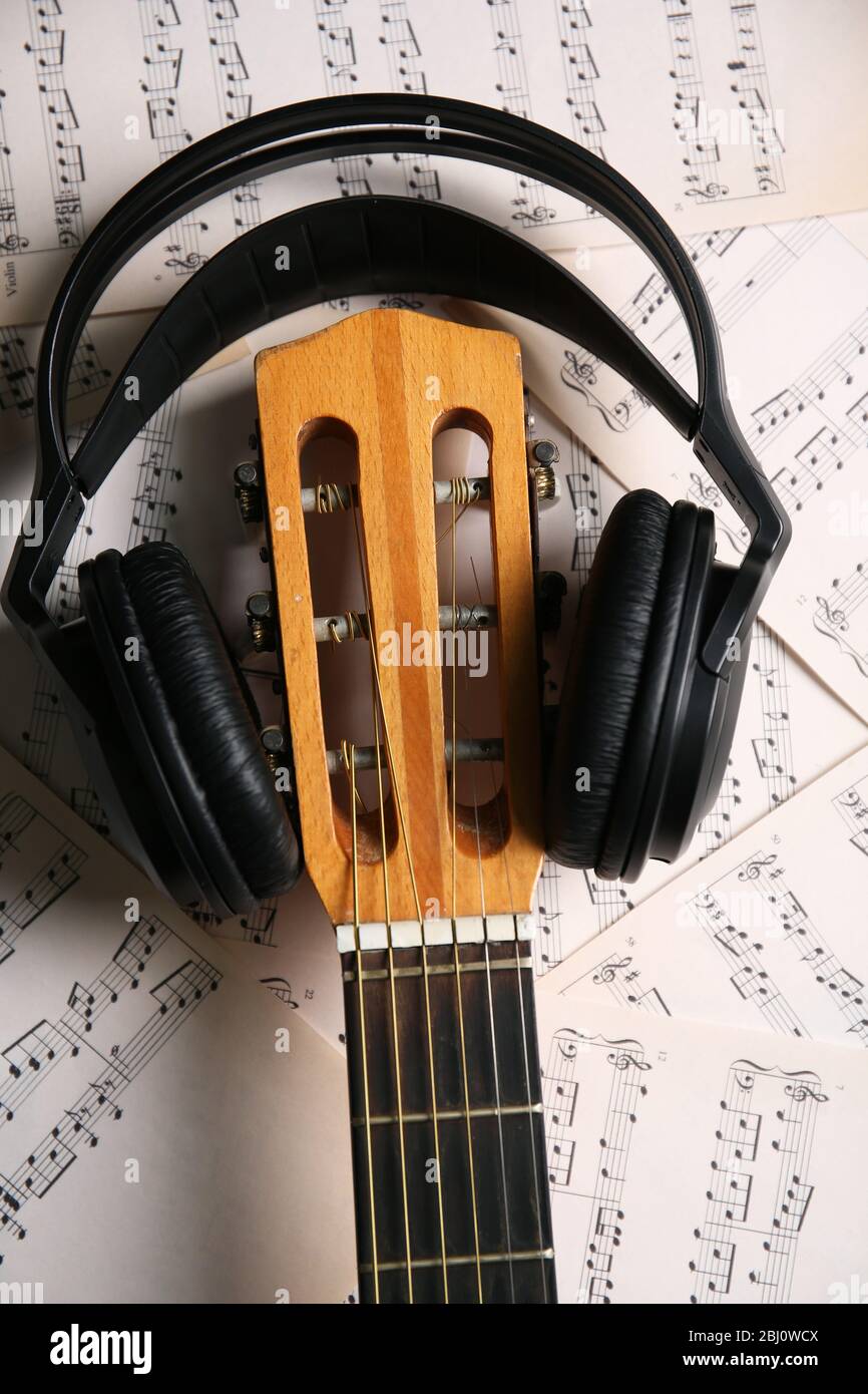 Music recording scene with guitar and headphones on music sheets ...