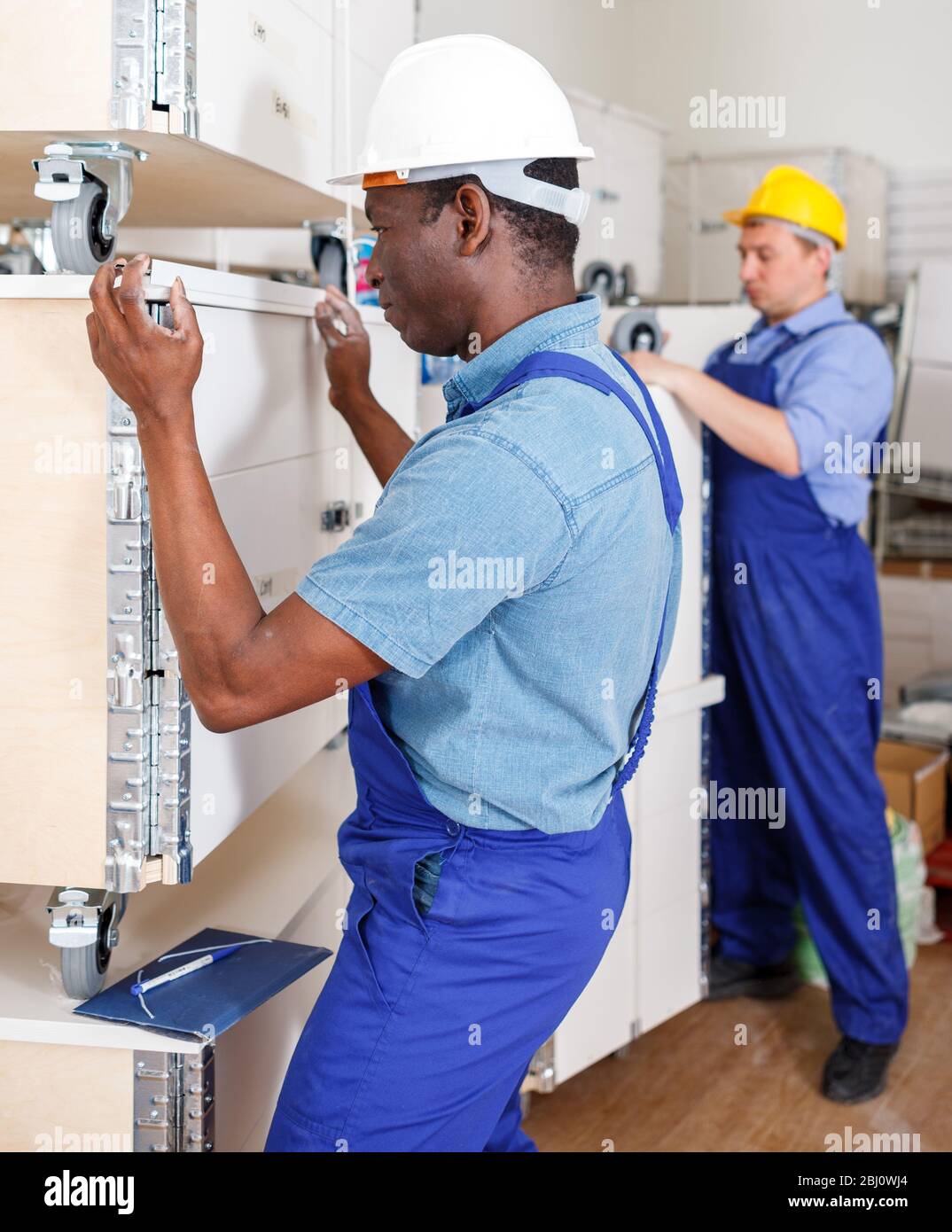Two male builders working at indoors building site Stock Photo - Alamy