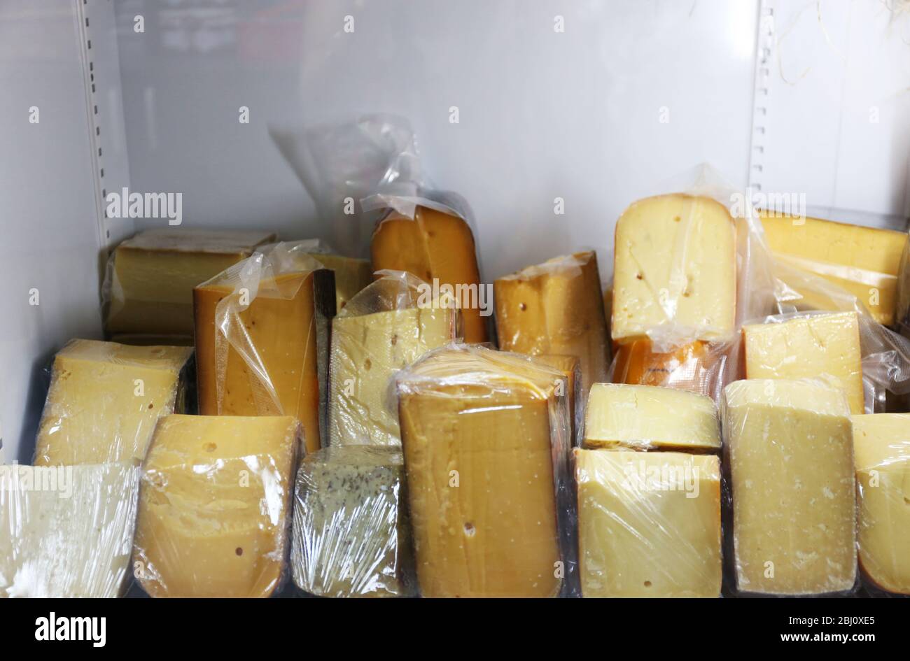 Set of cheese in plastic bags on shelf of fridge Stock Photo - Alamy