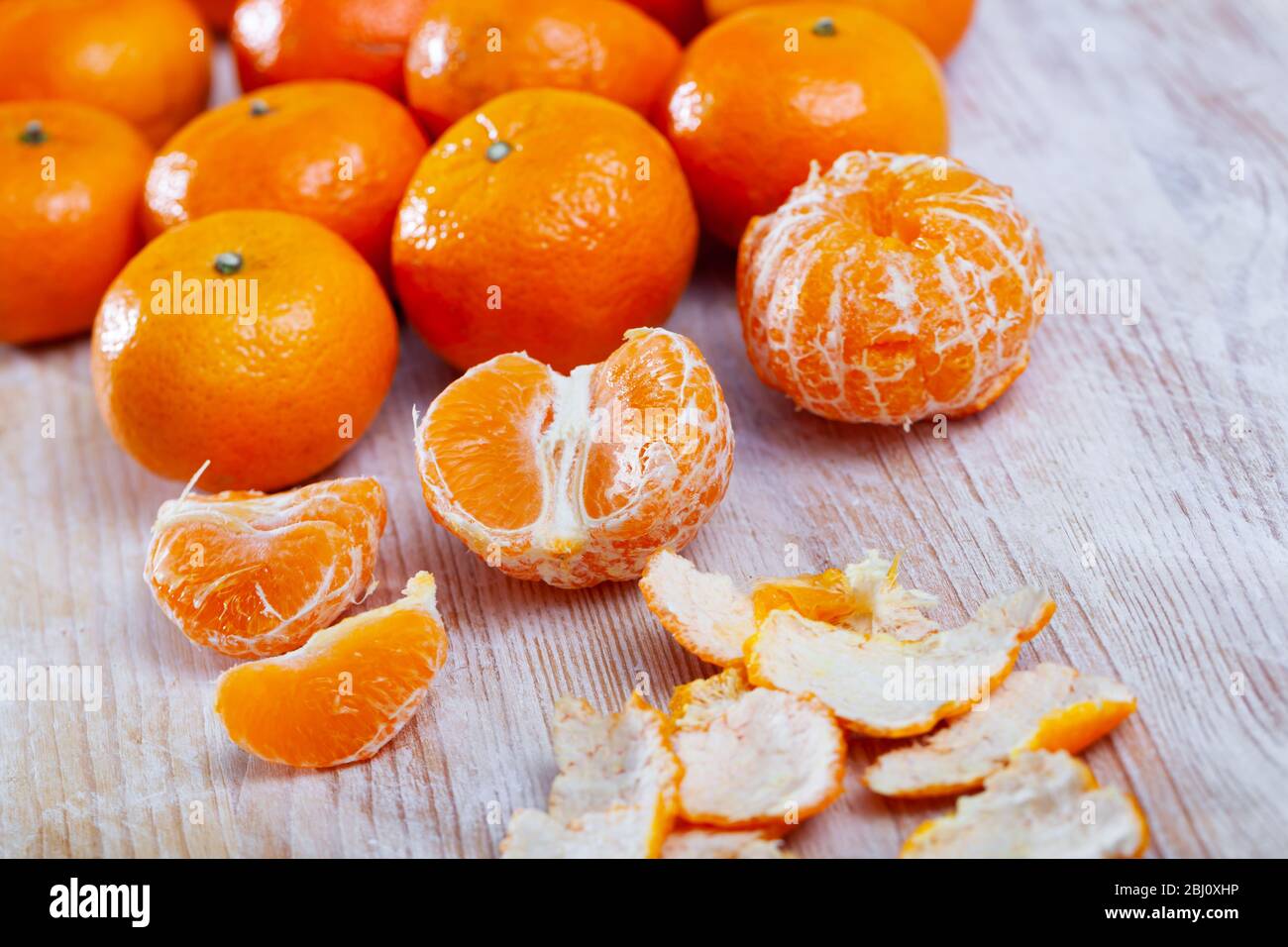 Peeled and whole fresh juicy clementines on wooden table. Concept of ...