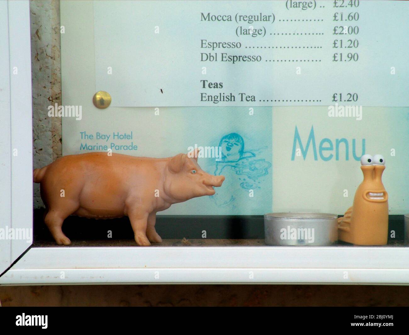Corner of restaurant window with menu and plastic pig Stock Photo - Alamy