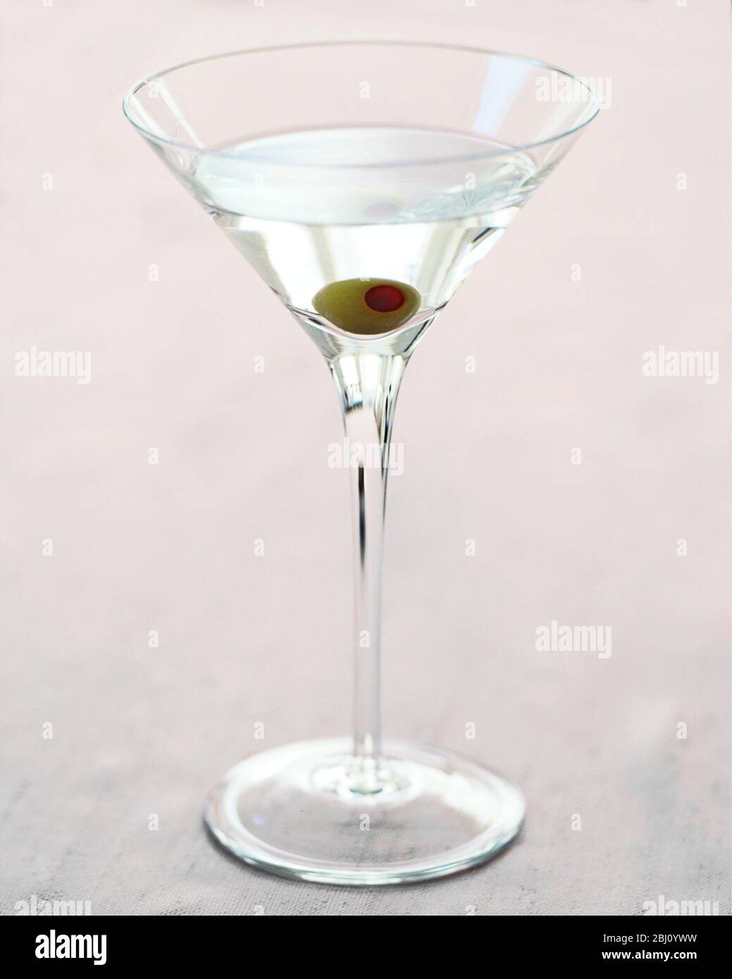 Dry martini or Vodkatini in classic cocktail glass with stuffed olive ...
