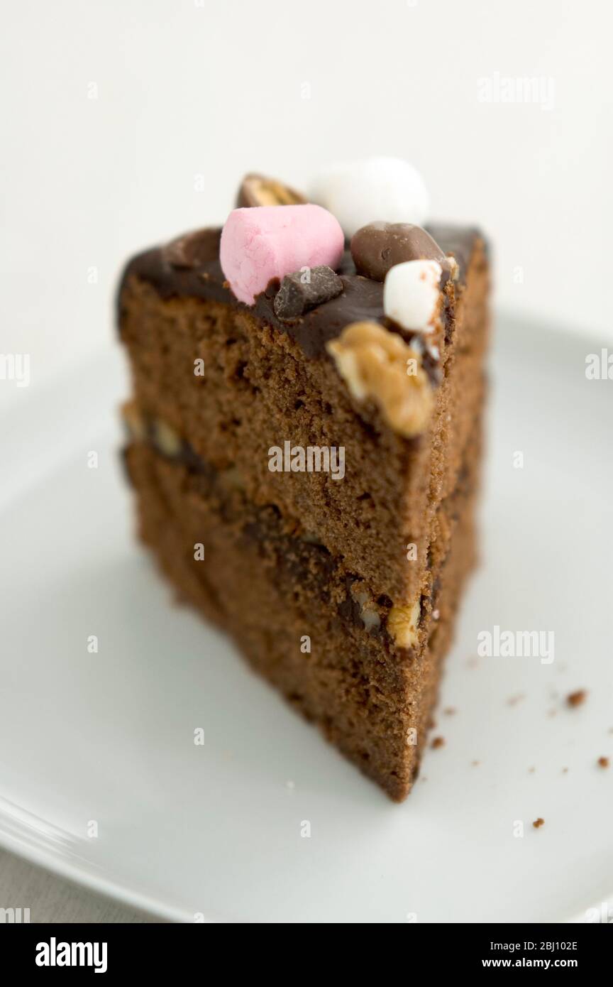 Slice of chocolate 'Rocky Road' cake topped with nuts, marshmalllows ...