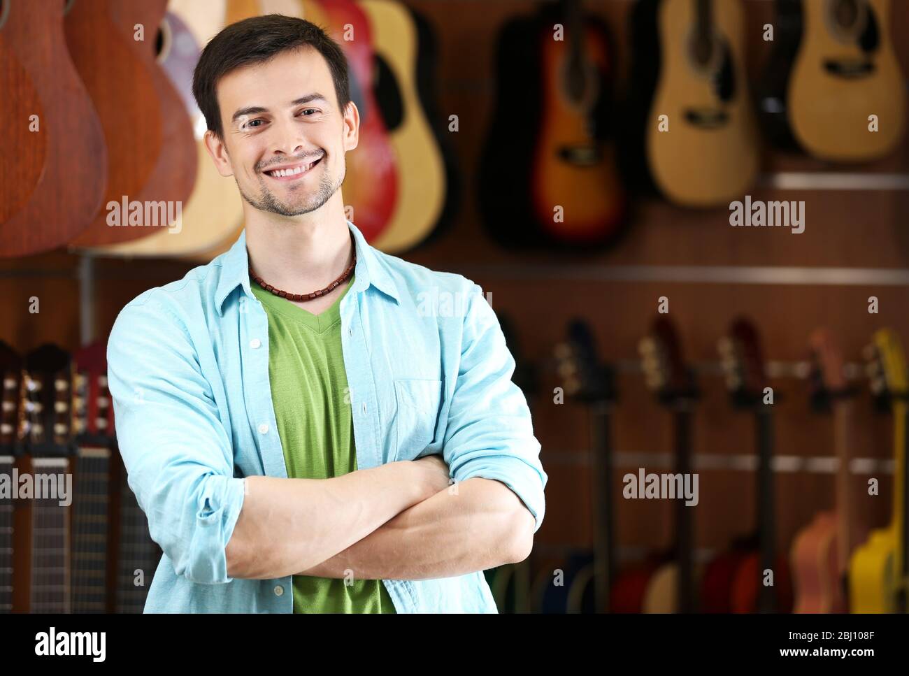 Handsome young man in music store Stock Photo - Alamy
