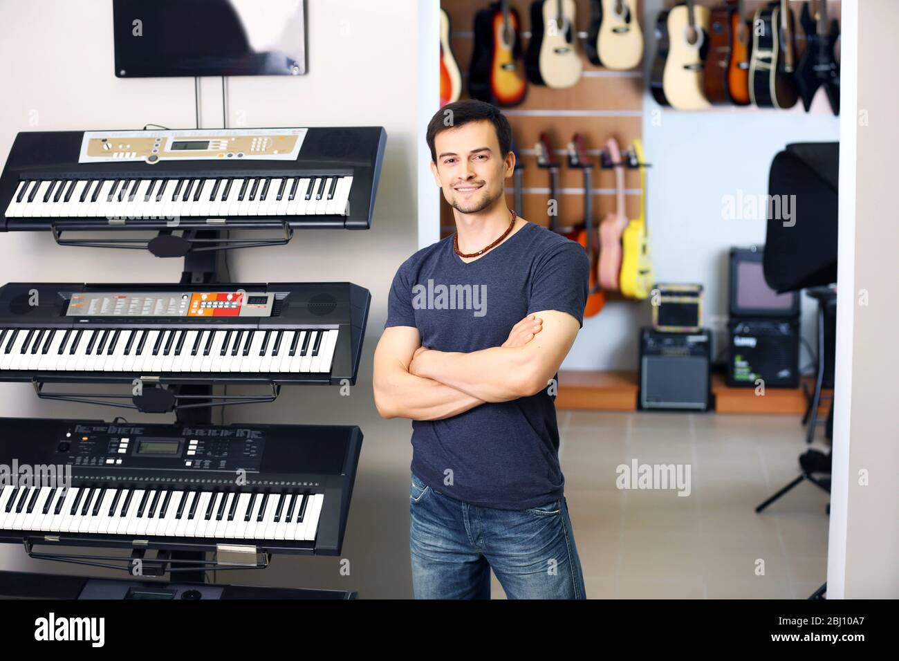 Handsome young man in music store Stock Photo - Alamy