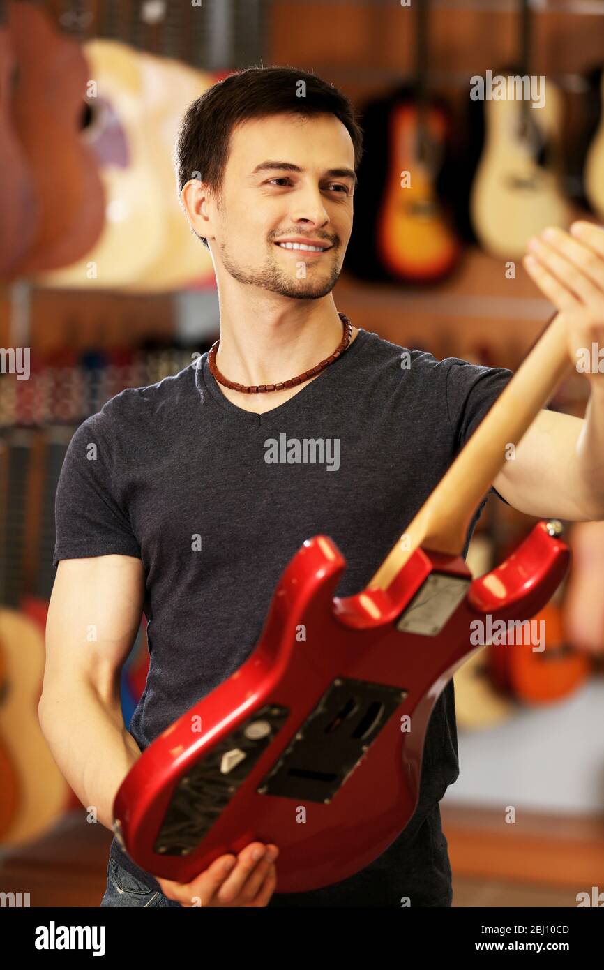 Handsome young man in music store Stock Photo - Alamy