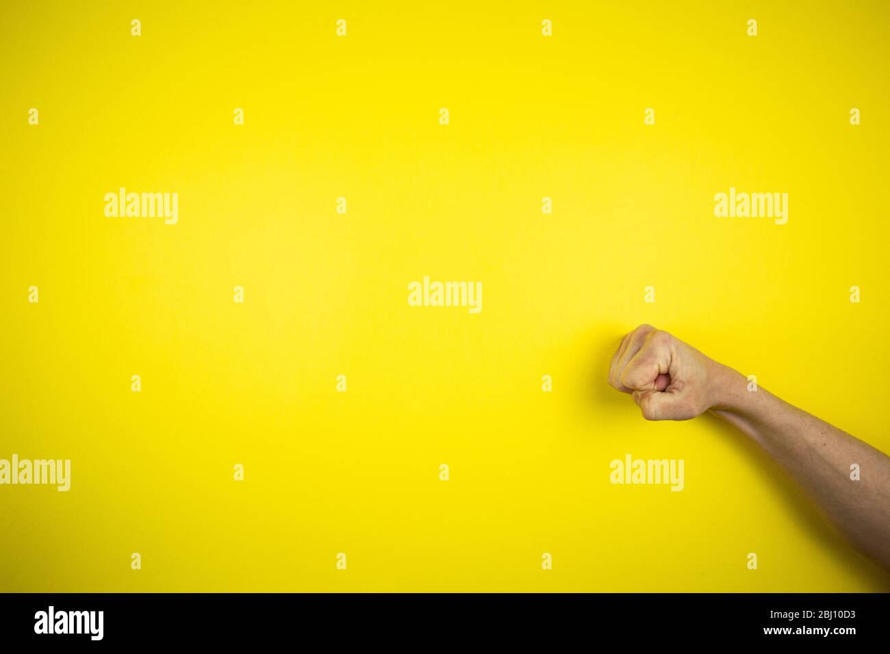 Punch, knock hand gesture on a yellow background Stock Photo - Alamy