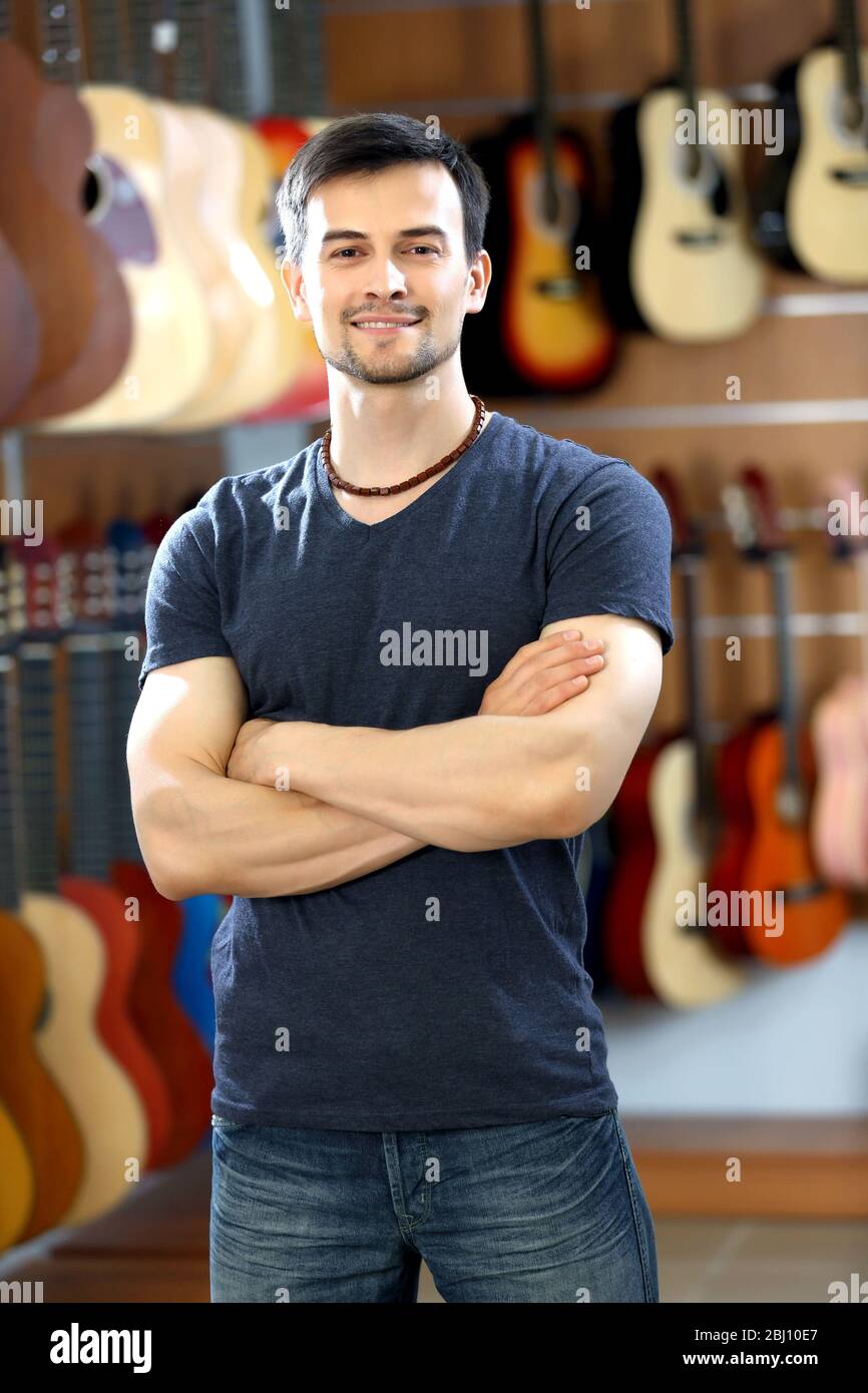 Handsome young man in music store Stock Photo - Alamy