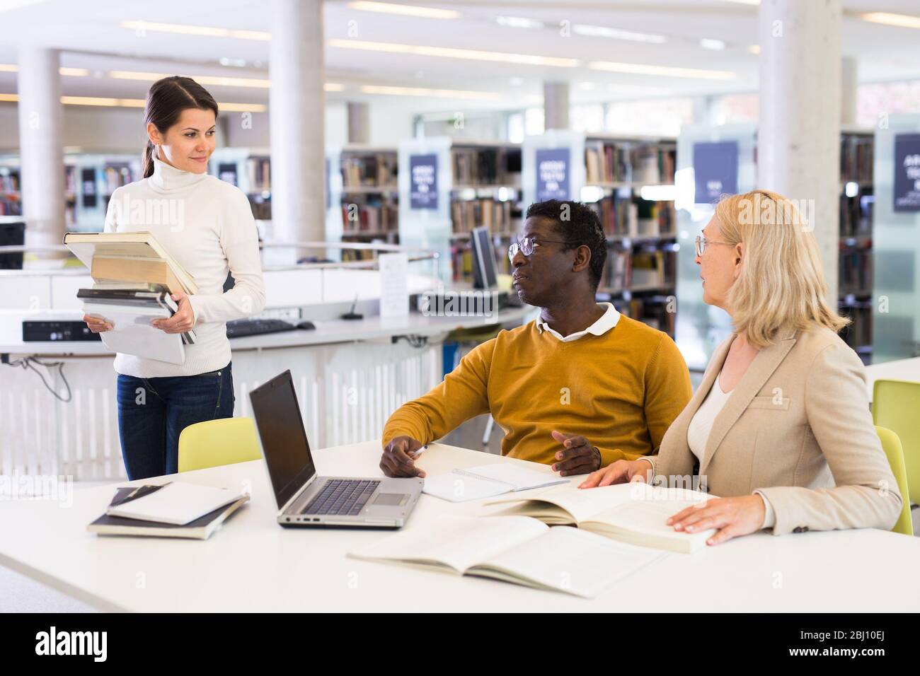 Professor and students communicate in the library Stock Photo - Alamy
