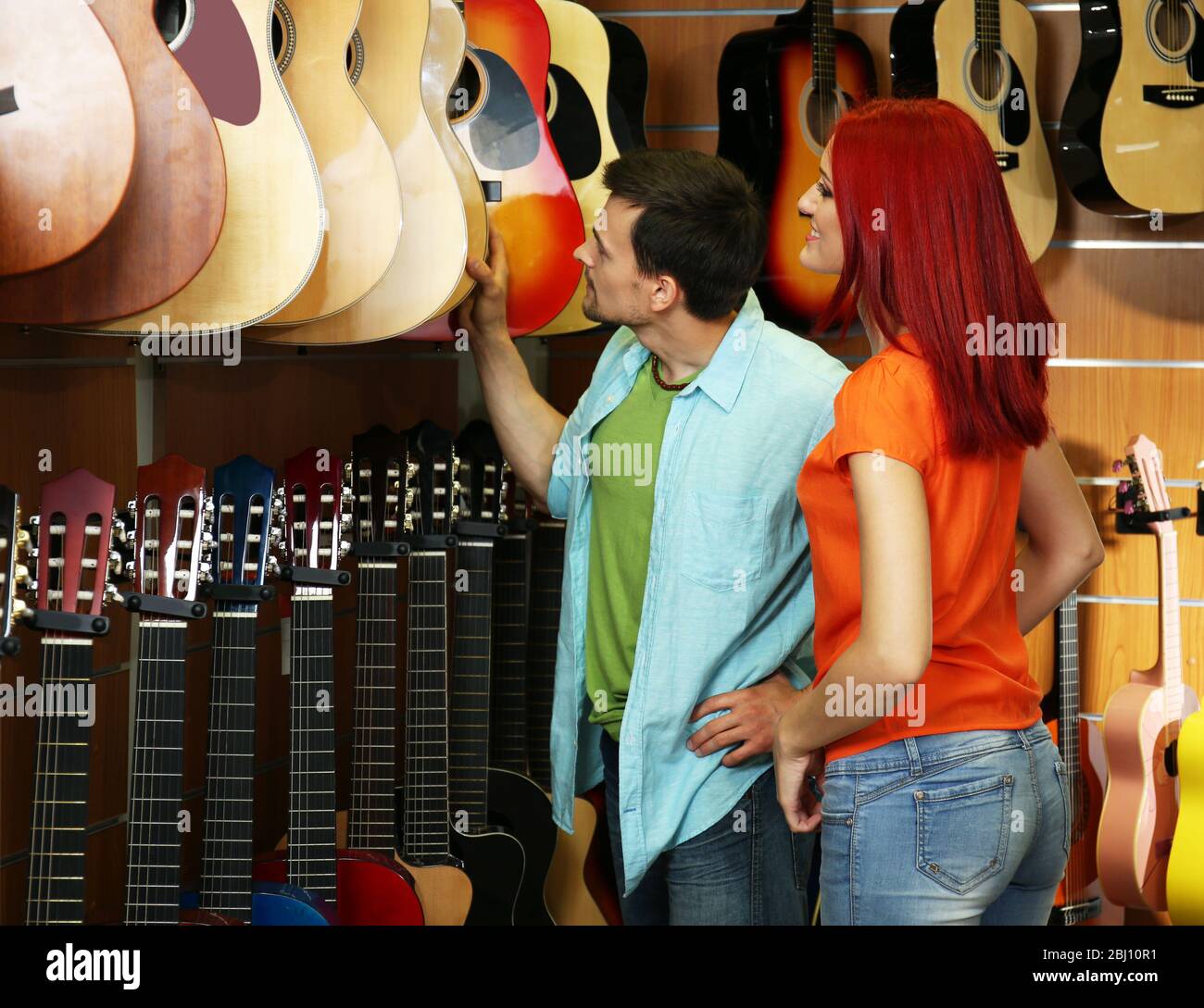 Beautiful young couple in music store Stock Photo - Alamy
