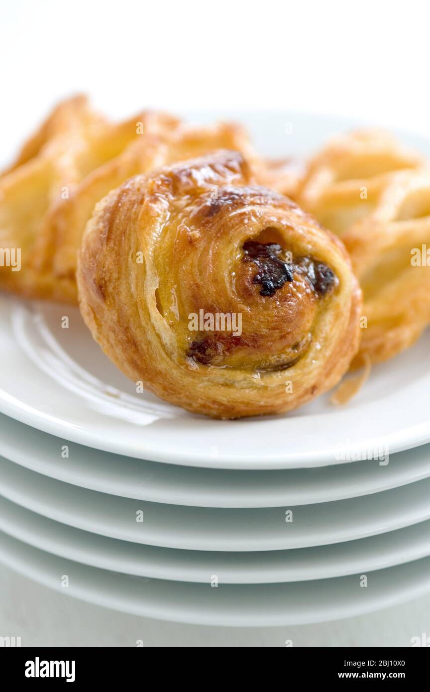 Small danish pastries on stack of white plates Stock Photo - Alamy