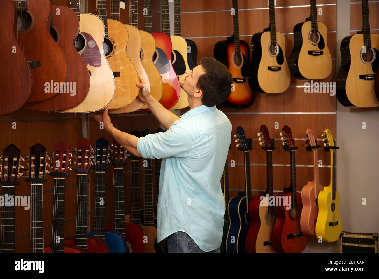 Handsome young man in music store Stock Photo - Alamy