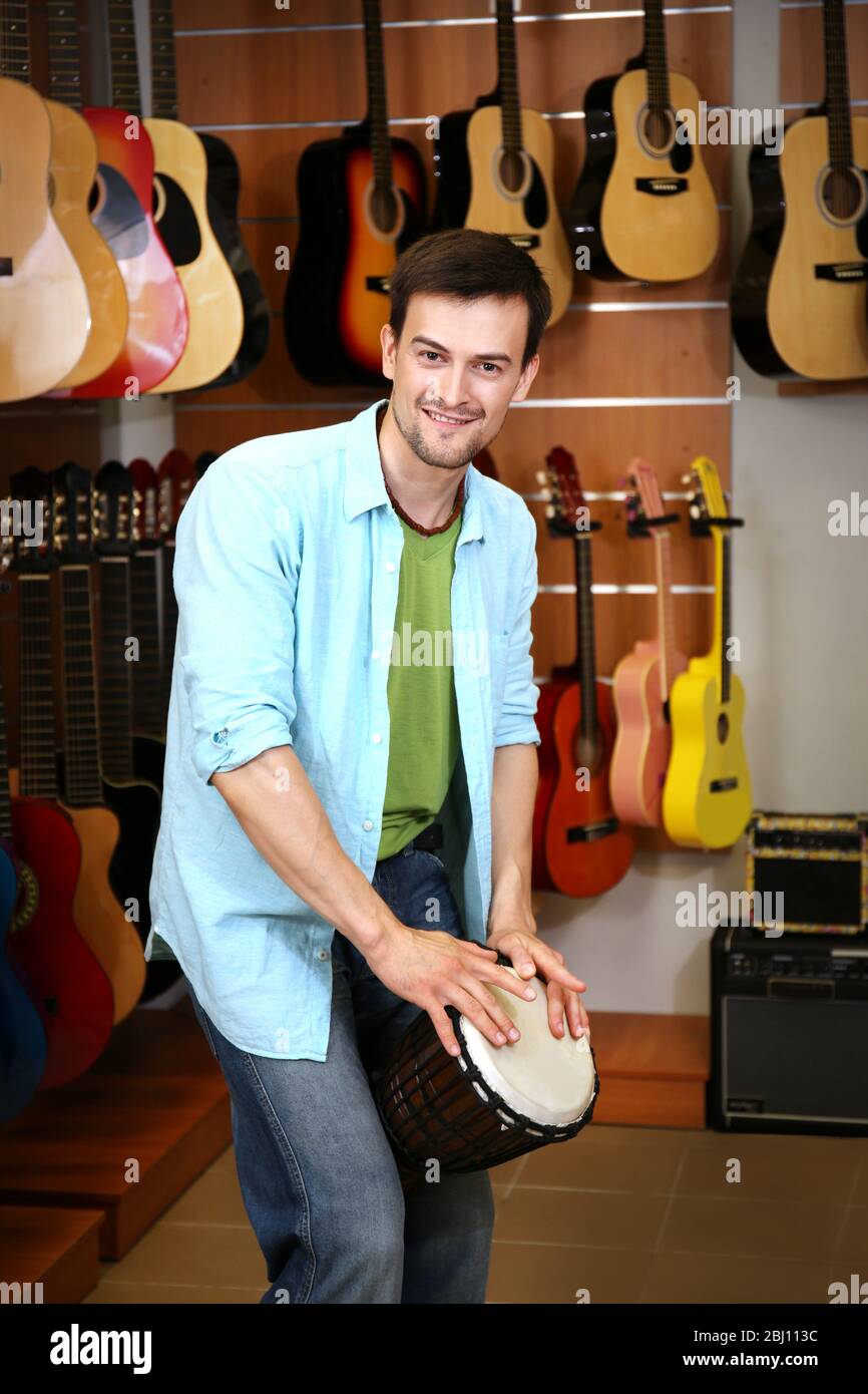 Handsome young man in music store Stock Photo - Alamy