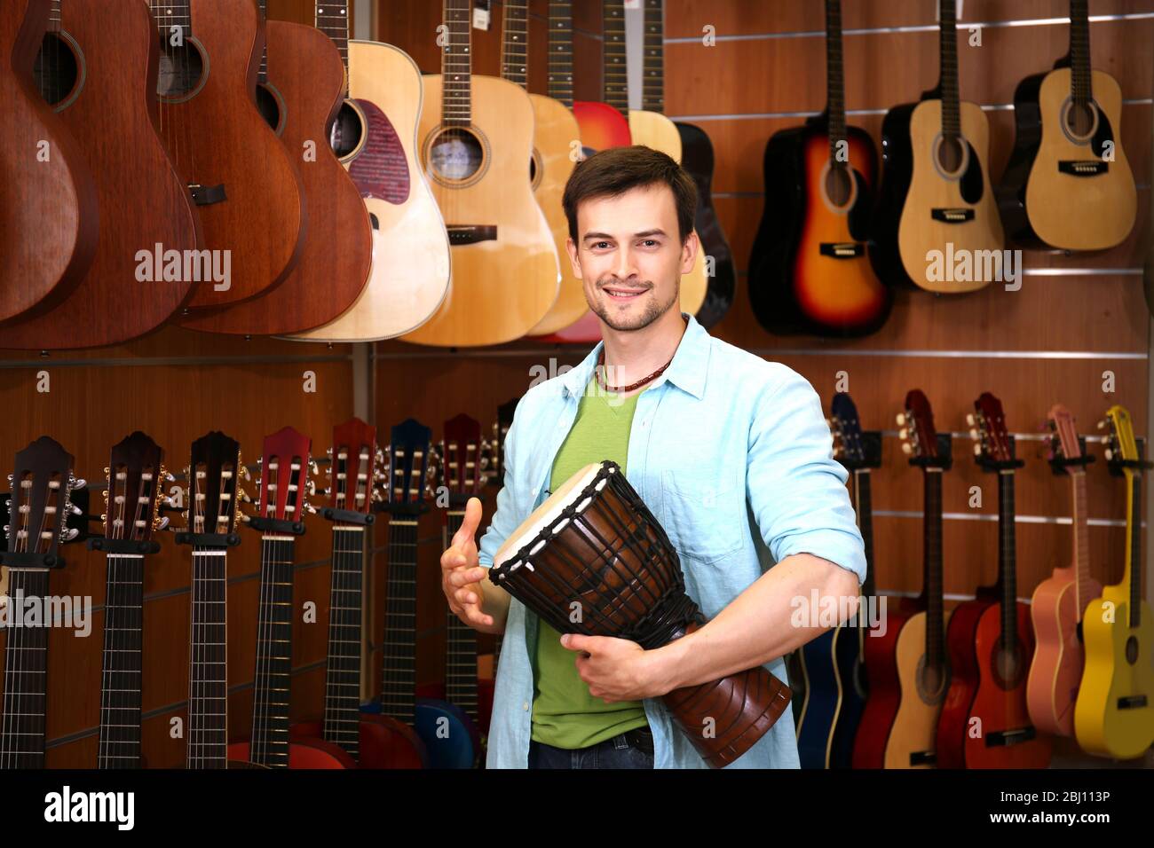 Handsome young man in music store Stock Photo - Alamy