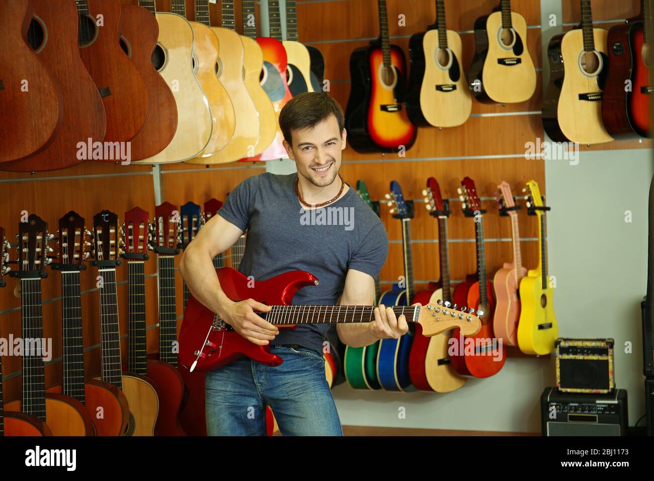 Handsome young man in music store Stock Photo - Alamy
