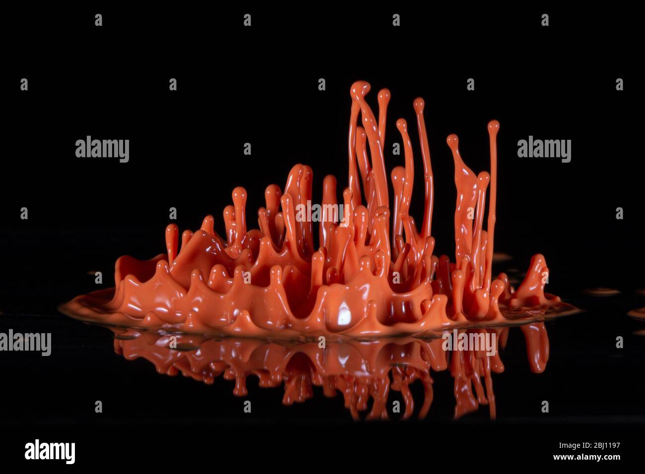 orange ink splash on a black background Stock Photo - Alamy